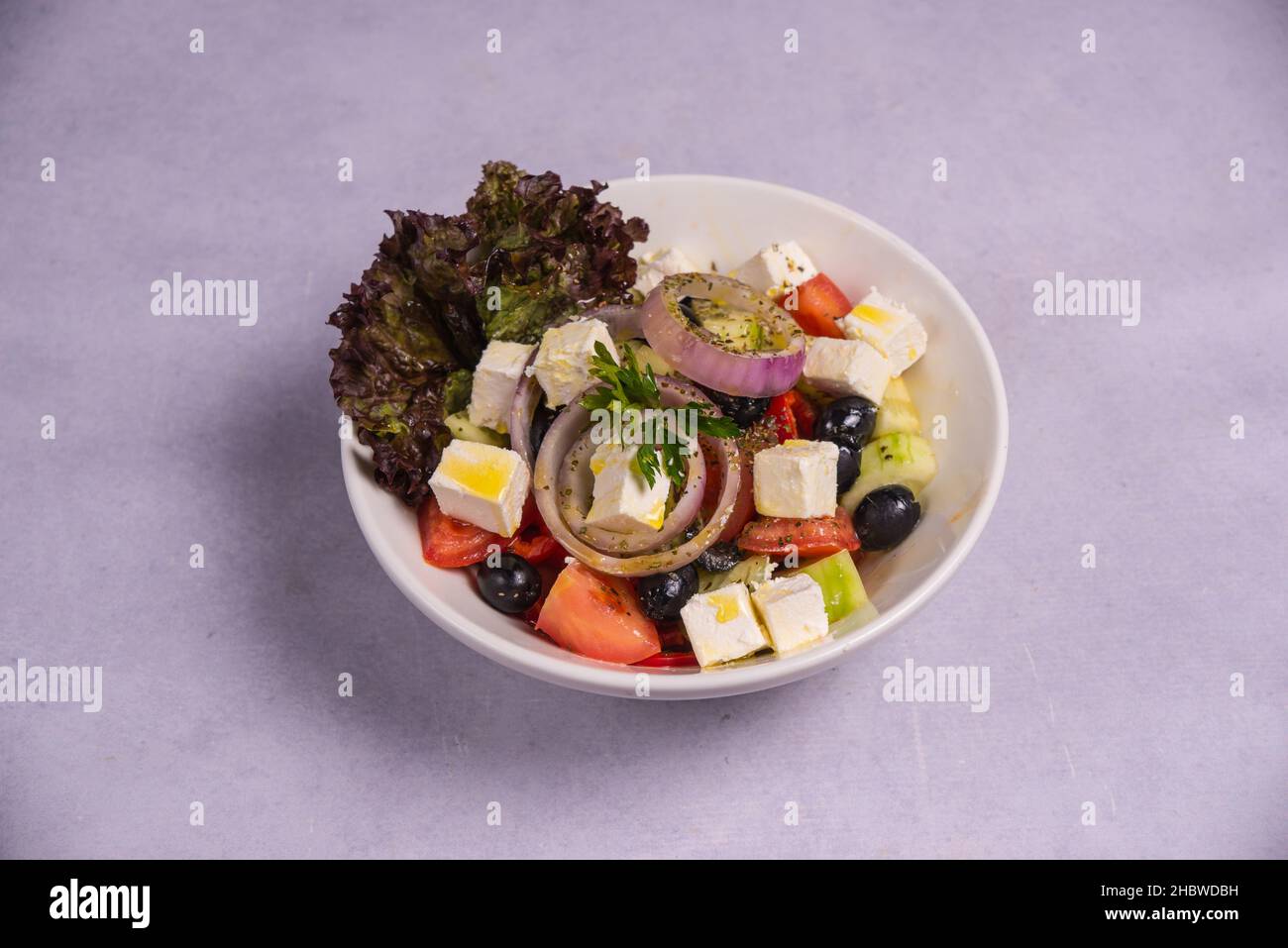 A closeup of a Greek salad with onions on top Stock Photo - Alamy