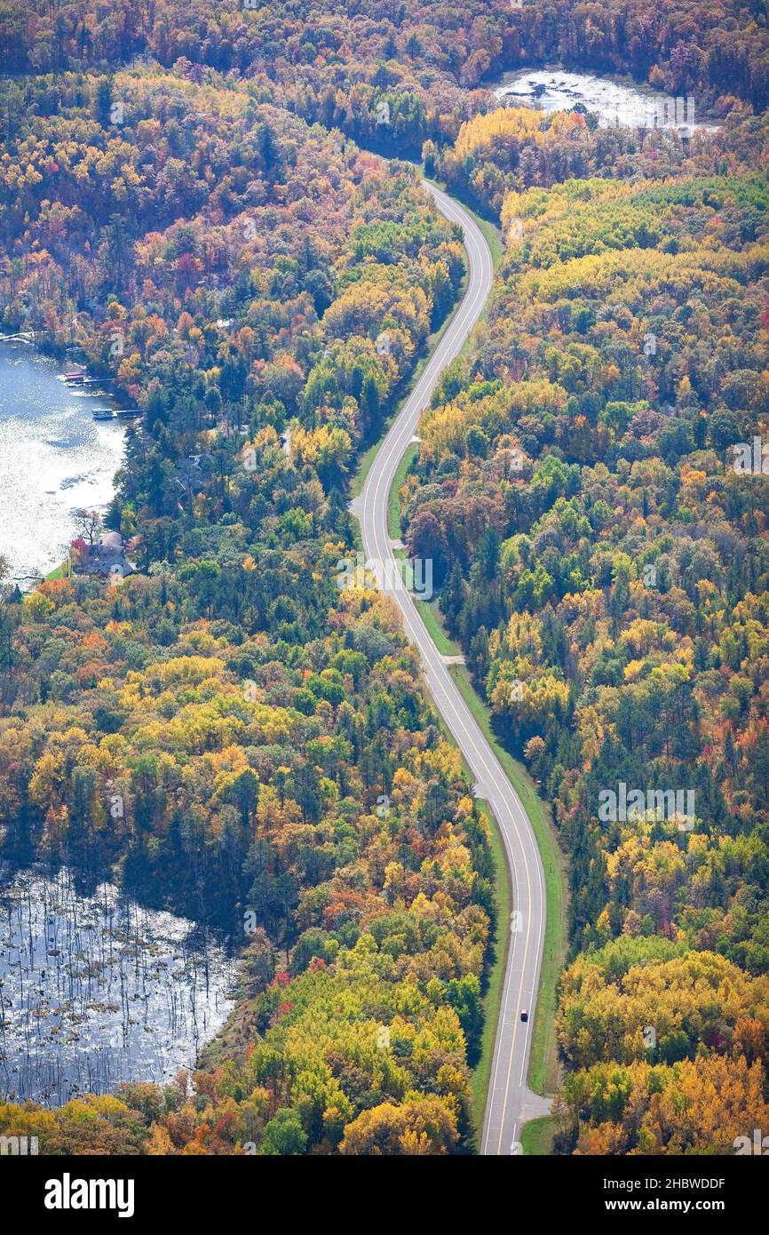 Aerial view of curving road and lakes and trees in northern Minnesota ...