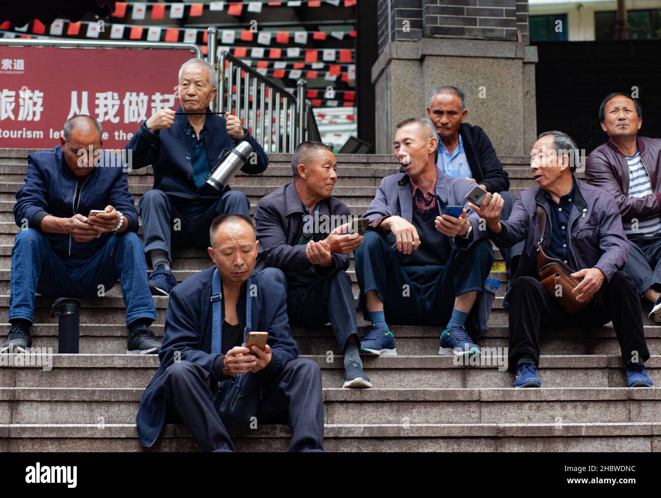Men sitting talking among them with cel phones. Chongqing. Republic ...