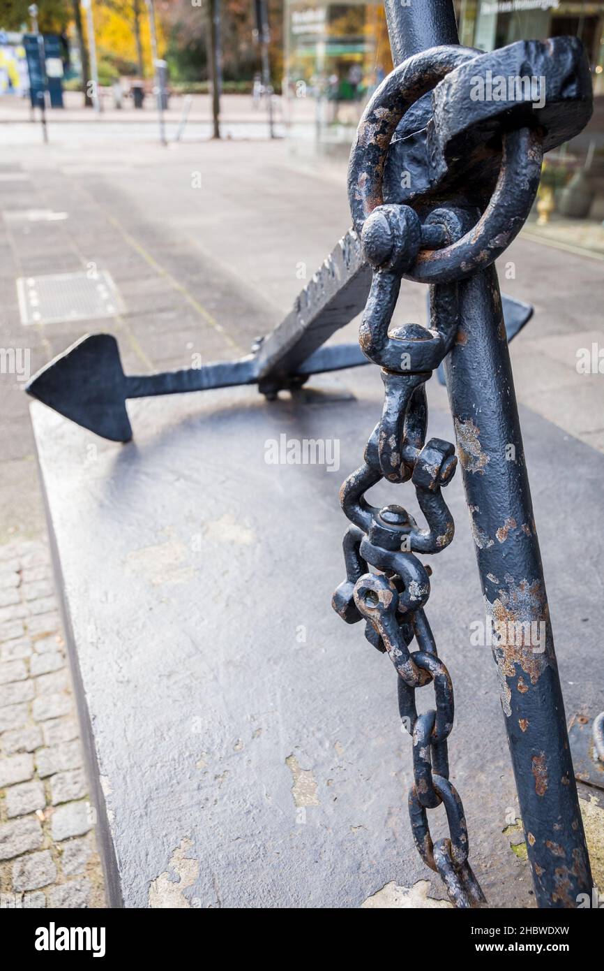 A vertical shot of a metallic rustic old chain statue on the street ...