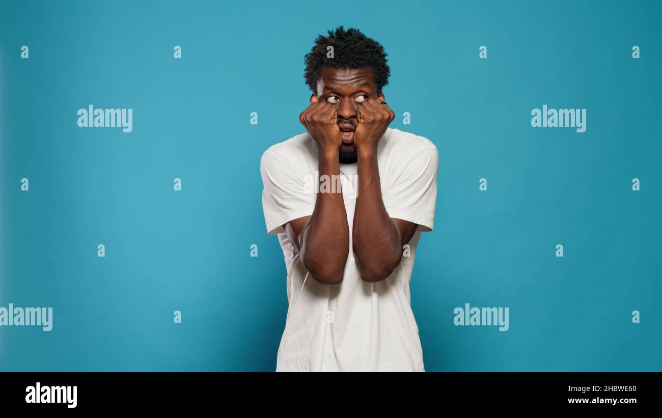 Portrait of frightened man having hands on mouth. Scared person feeling ...