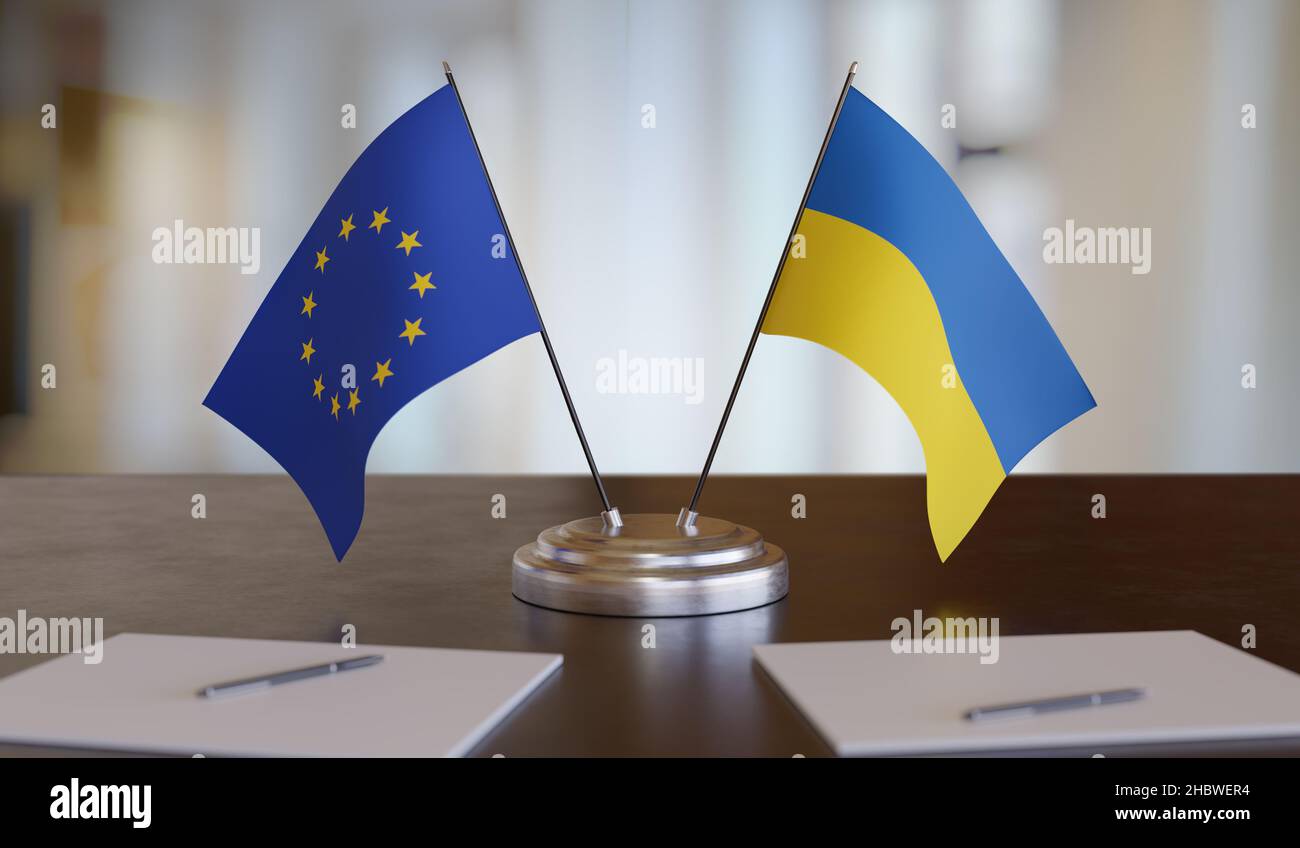 Ukrainian and EU flags on table. Negotiation between European Union and ...
