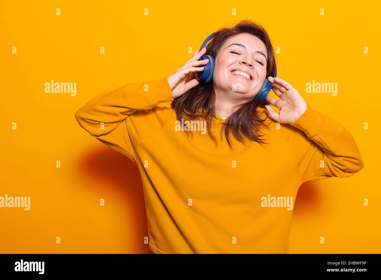 Smiling person feeling happy and listening to music, using modern ...