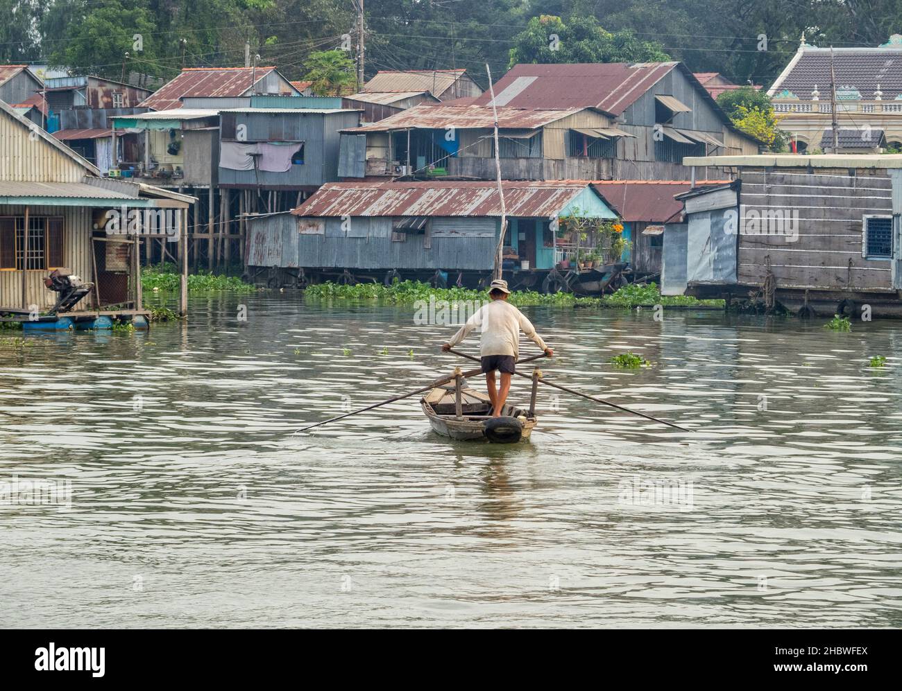 A man is rowing his small wooden boat across the Bassac River - Chau ...