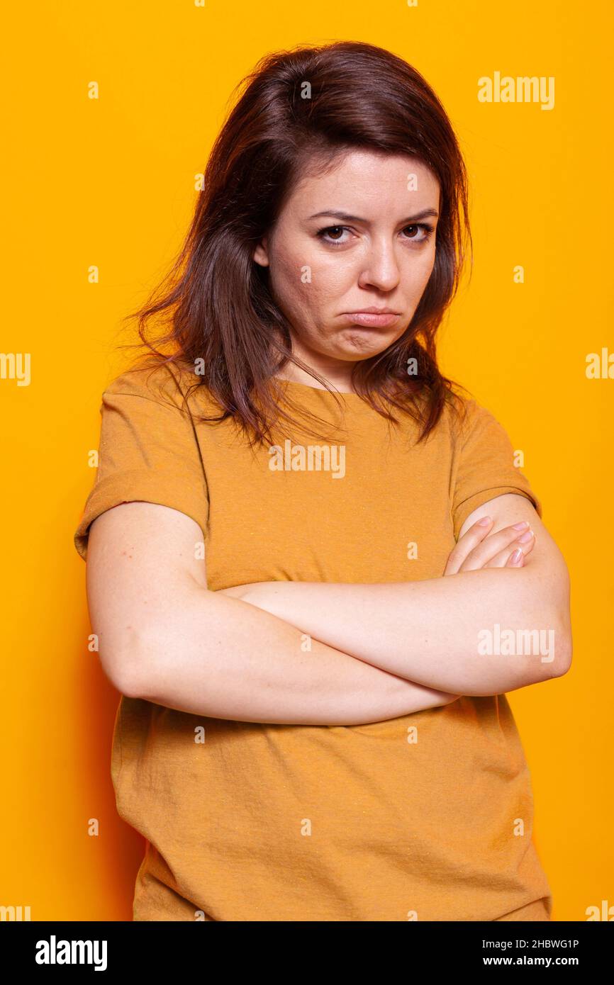 Annoyed woman posing with crossed arms on camera, showing disapproving ...