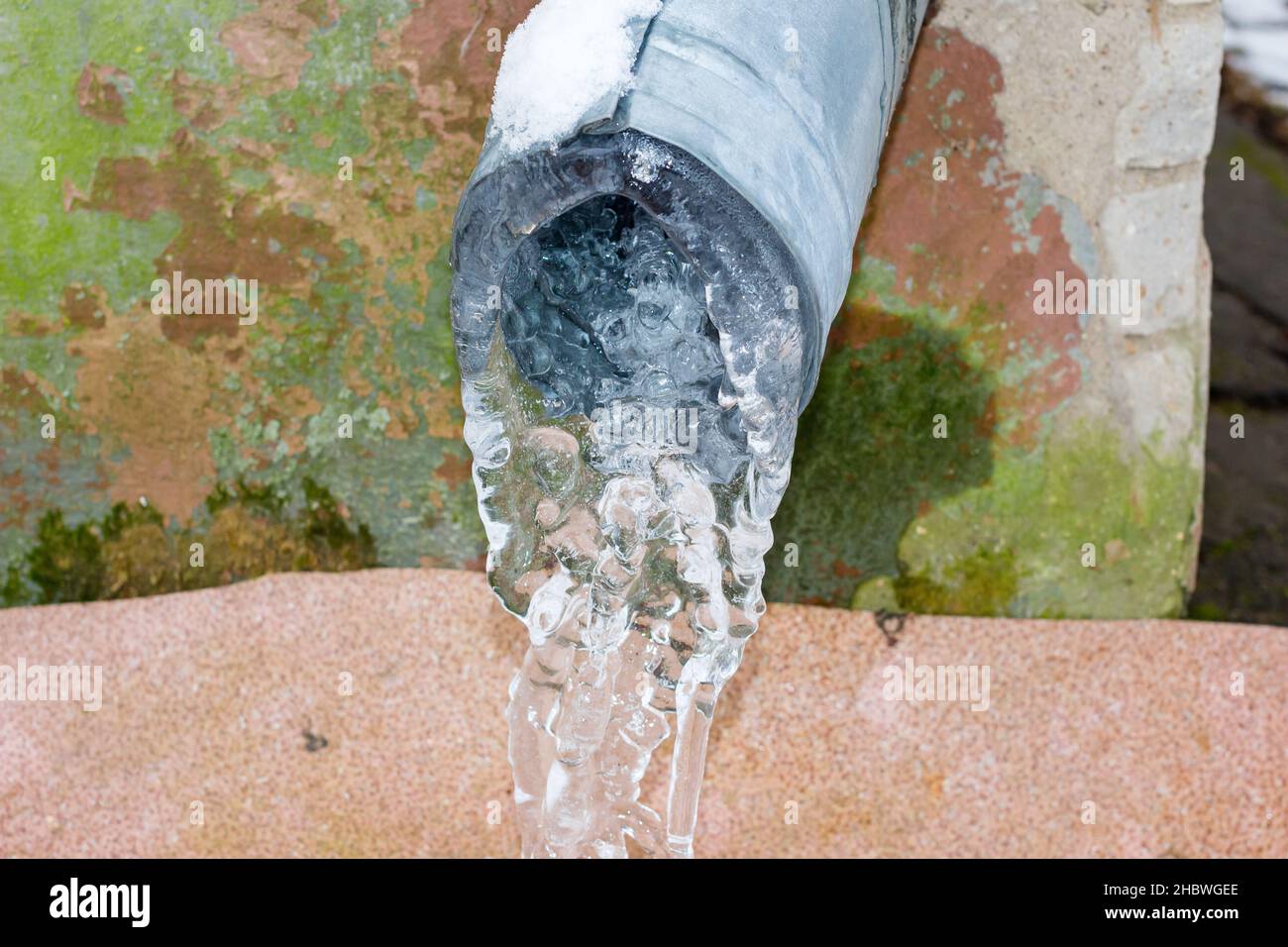 Large ice in the rain gutter on the house Stock Photo - Alamy