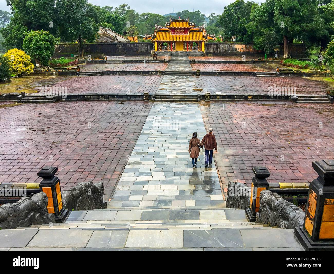Two people waling in al large open area between tombs Stock Photo - Alamy