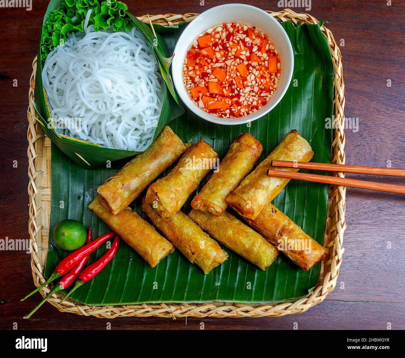 Square platter with Vietnamese Spring Rolls, red chili pepper and rice ...