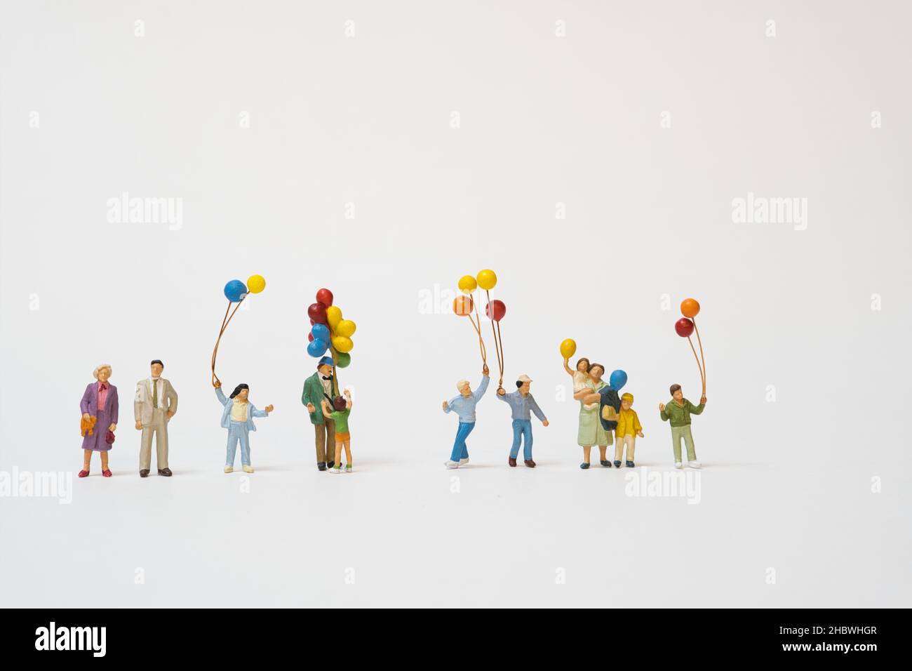 A miniature balloon seller and a happy family with colorful balloons ...