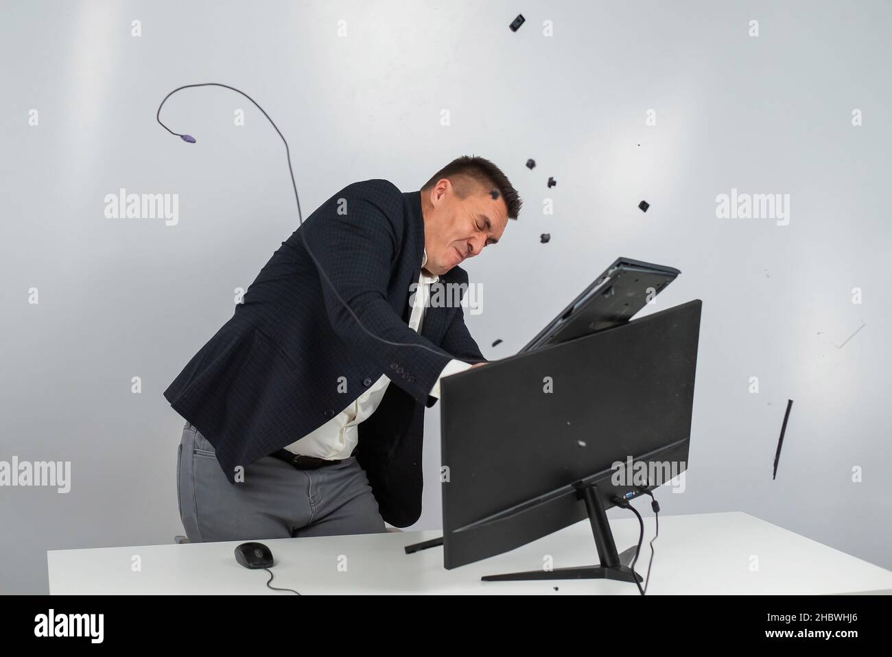 Caucasian man in a suit gets angry and smashes the keyboard on the ...