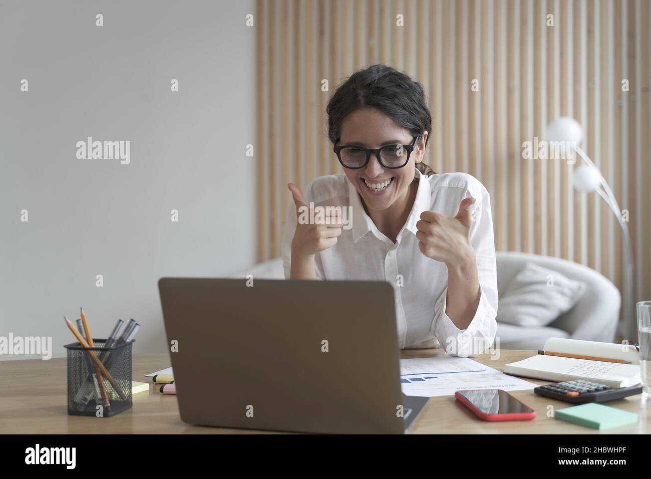 Business lady looking at `computer screen with broad smile while ...