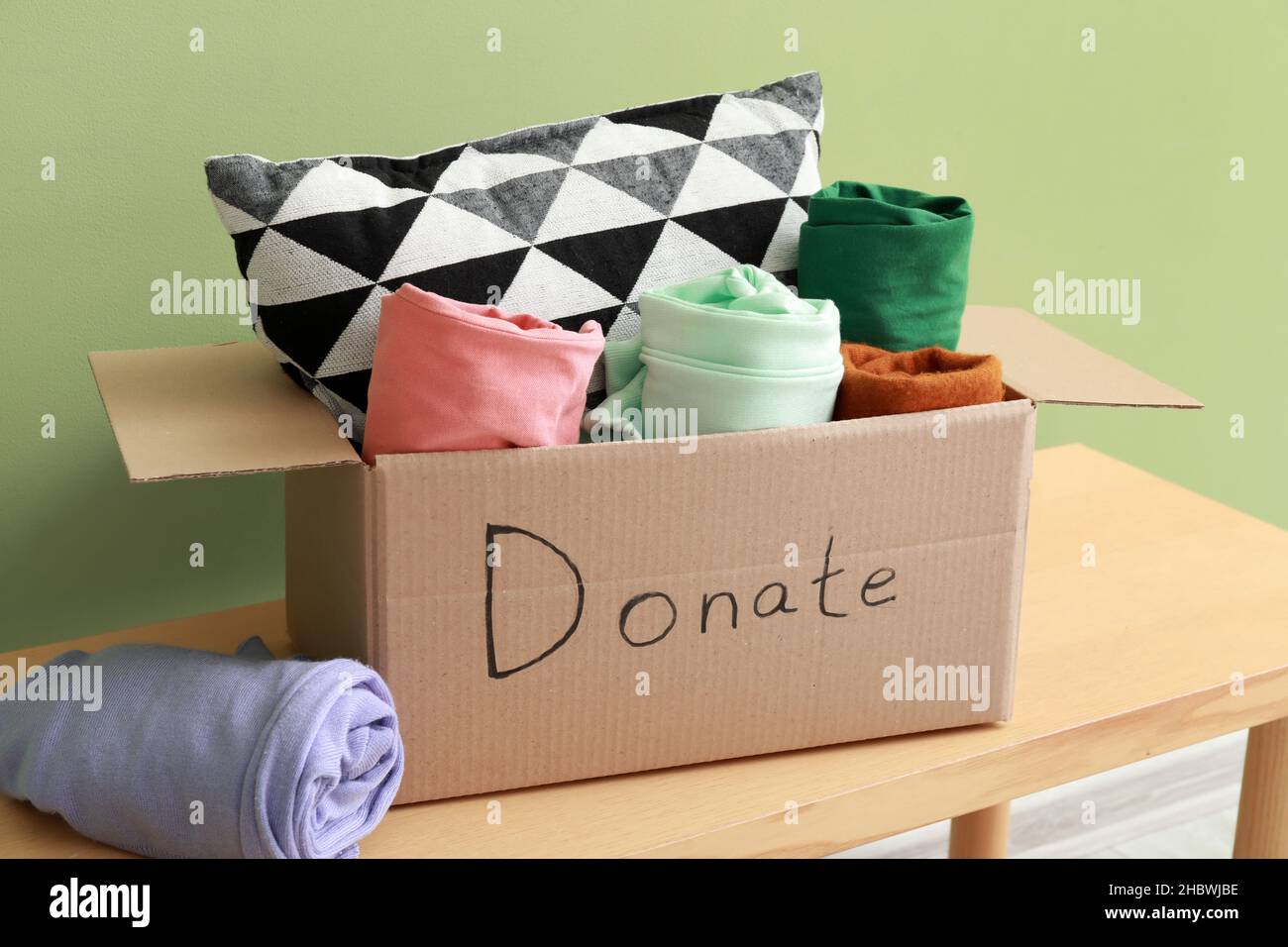 Cardboard box with donations on bench against green background Stock ...