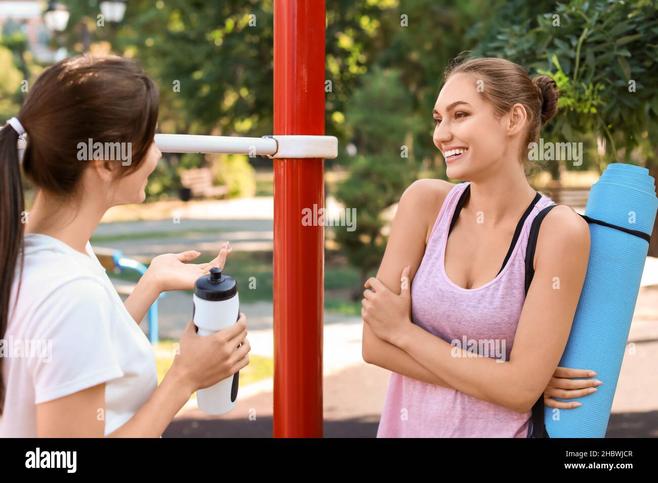 Sporty young women talking on sport ground Stock Photo - Alamy
