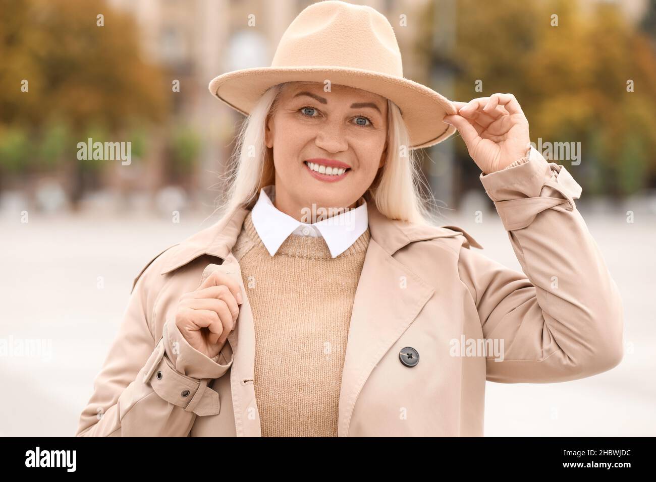 Elegant mature woman in stylish felt hat on city street Stock Photo - Alamy