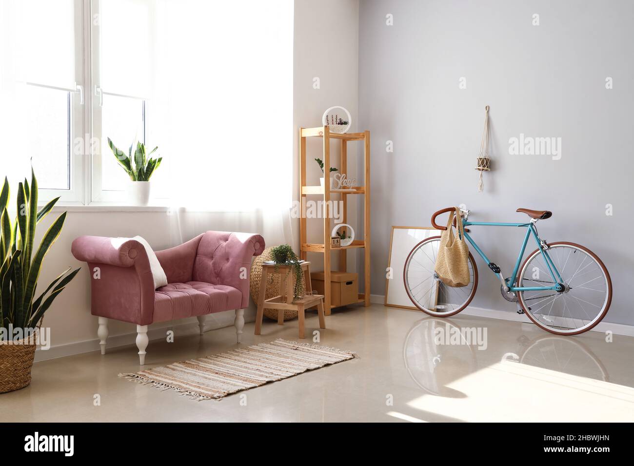 Interior of light living room with pink armchair, shelving unit and ...