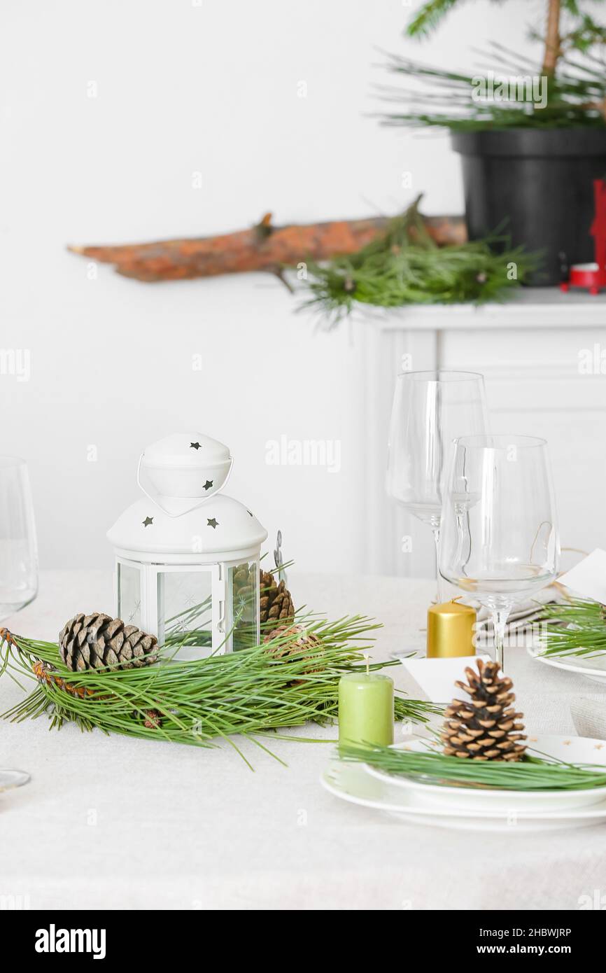 Beautiful table setting with pine cones and fir branches indoors Stock ...