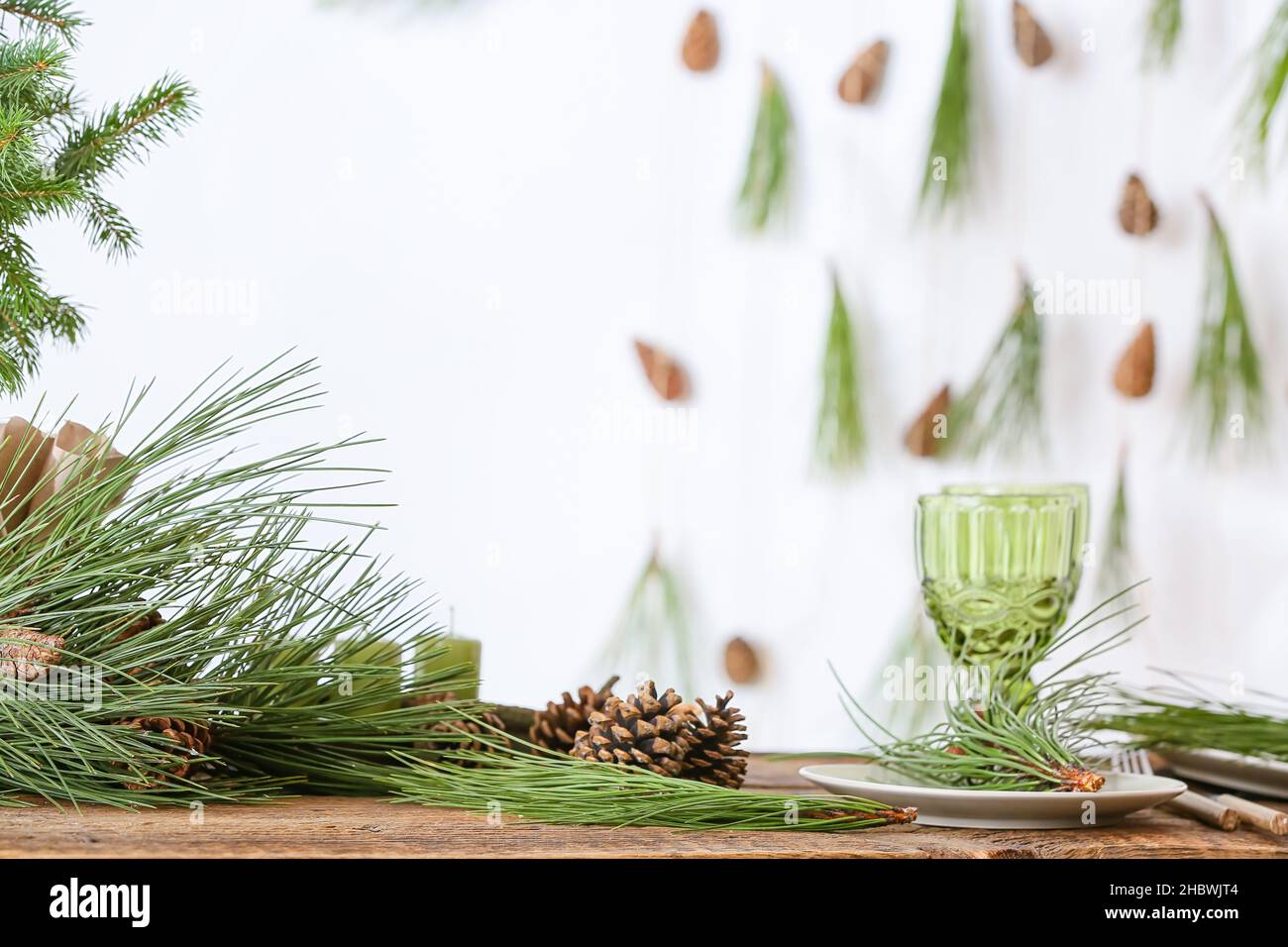 Beautiful table setting with pine cones and fir branches near white ...