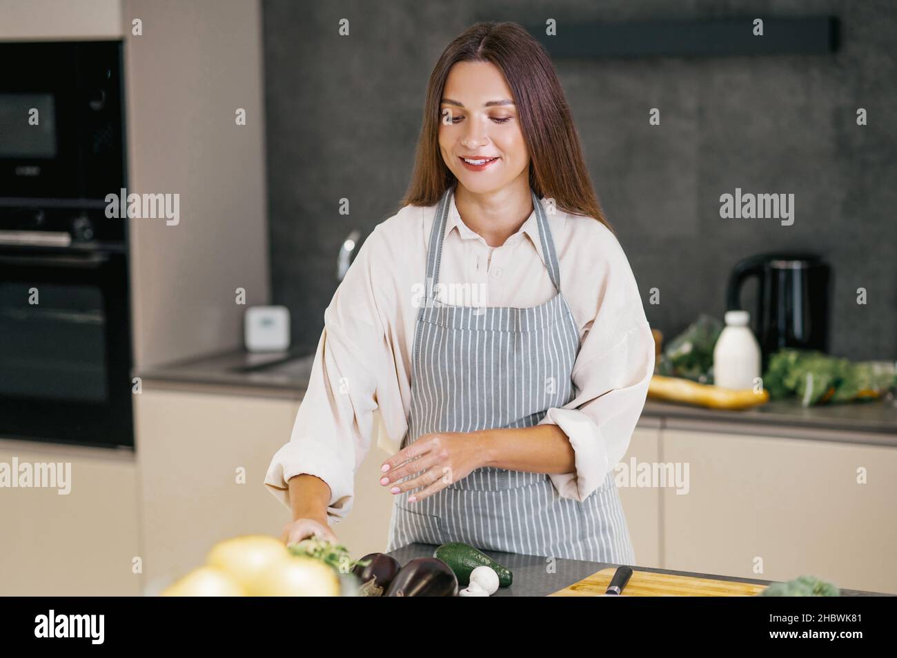 Long-haired young woman preparing lunch in the kitchen Stock Photo - Alamy