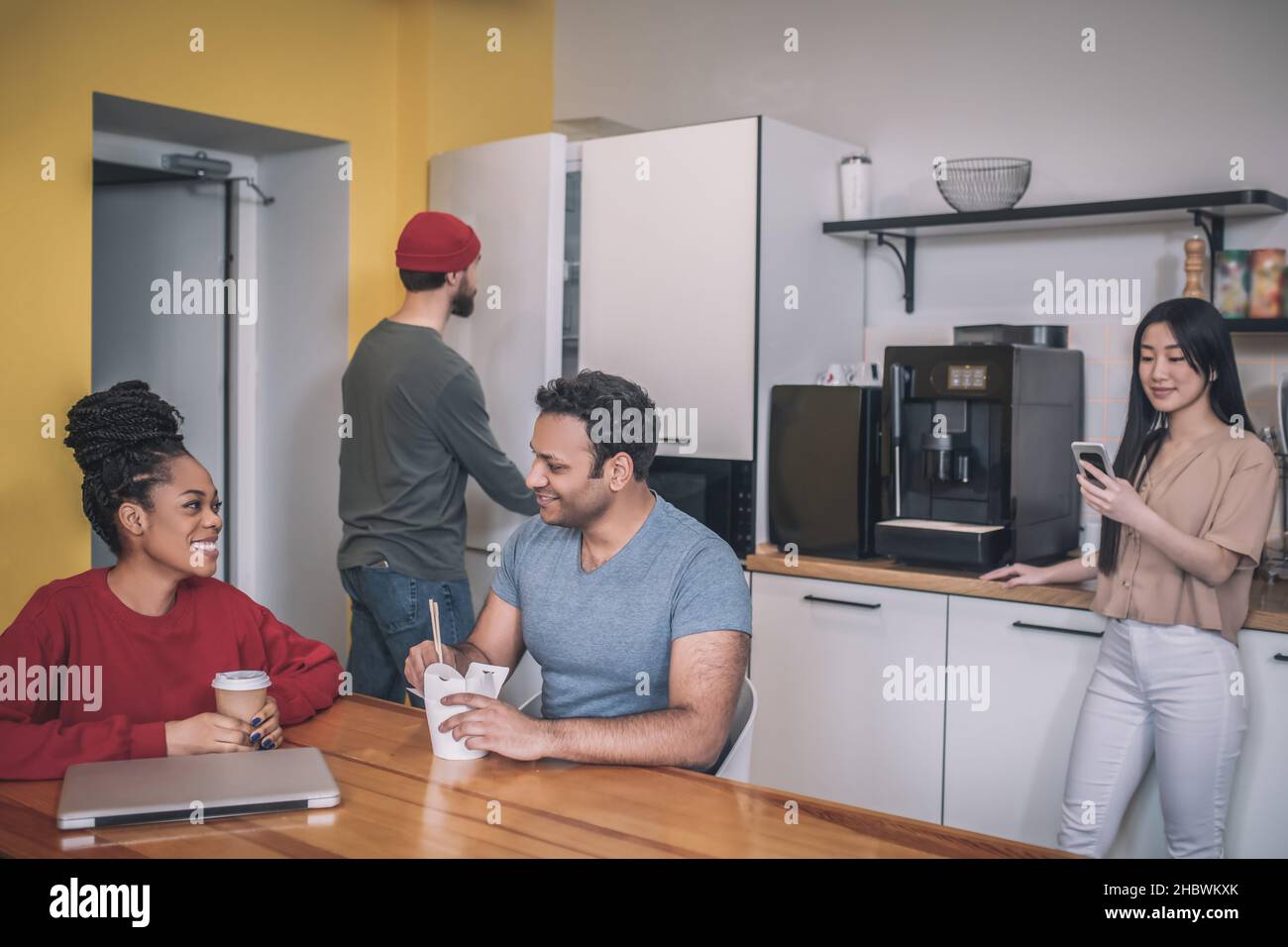 Young colleagues having lunch in office kitchen Stock Photo - Alamy