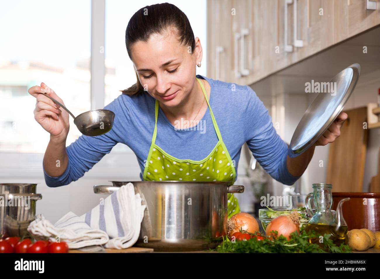 Housewife tasting soup at kitchen Stock Photo - Alamy