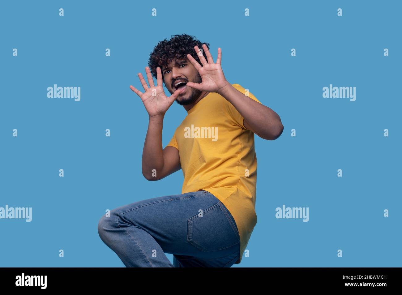 Scared young man showing the Stop gesture Stock Photo - Alamy