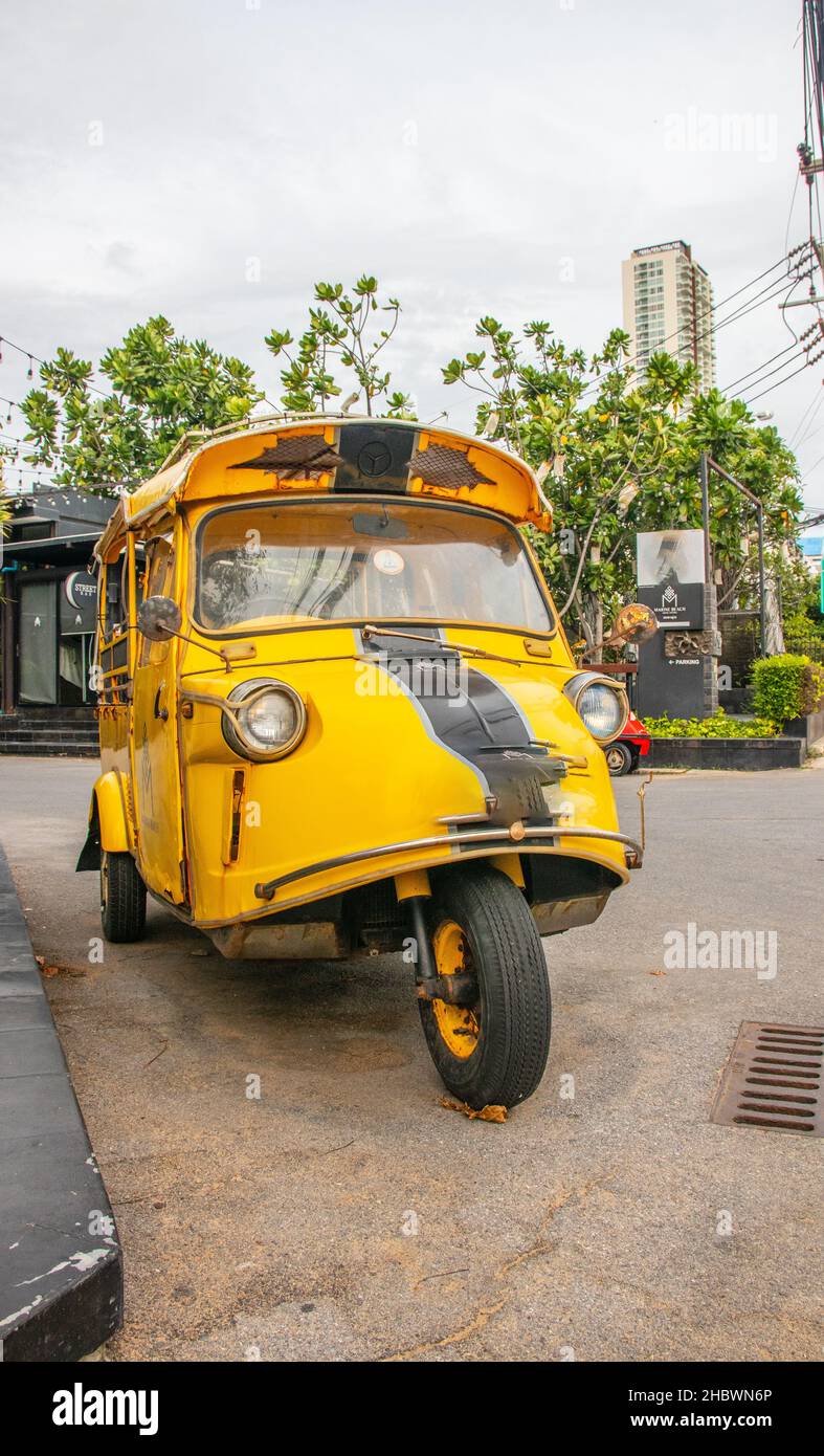 A yellow tuk tuk vehicle parked in the street Stock Photo - Alamy