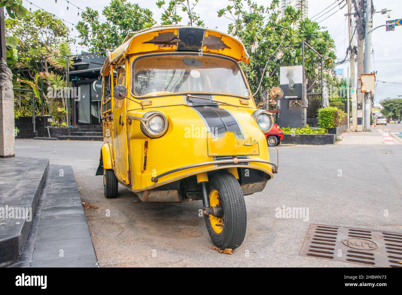A yellow tuk tuk vehicle parked in the street Stock Photo - Alamy