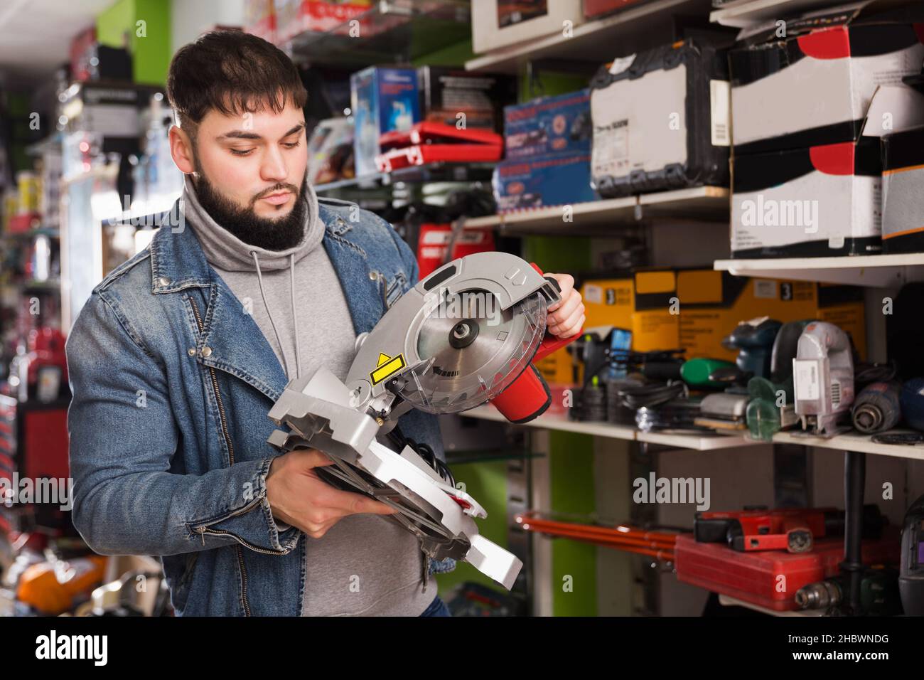 male engineer chooses circular saw in tool store Stock Photo - Alamy