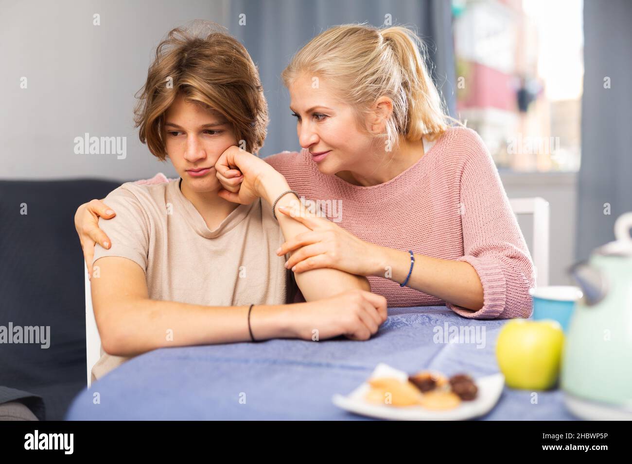 Mother and son sitting after quarrel at home Stock Photo - Alamy