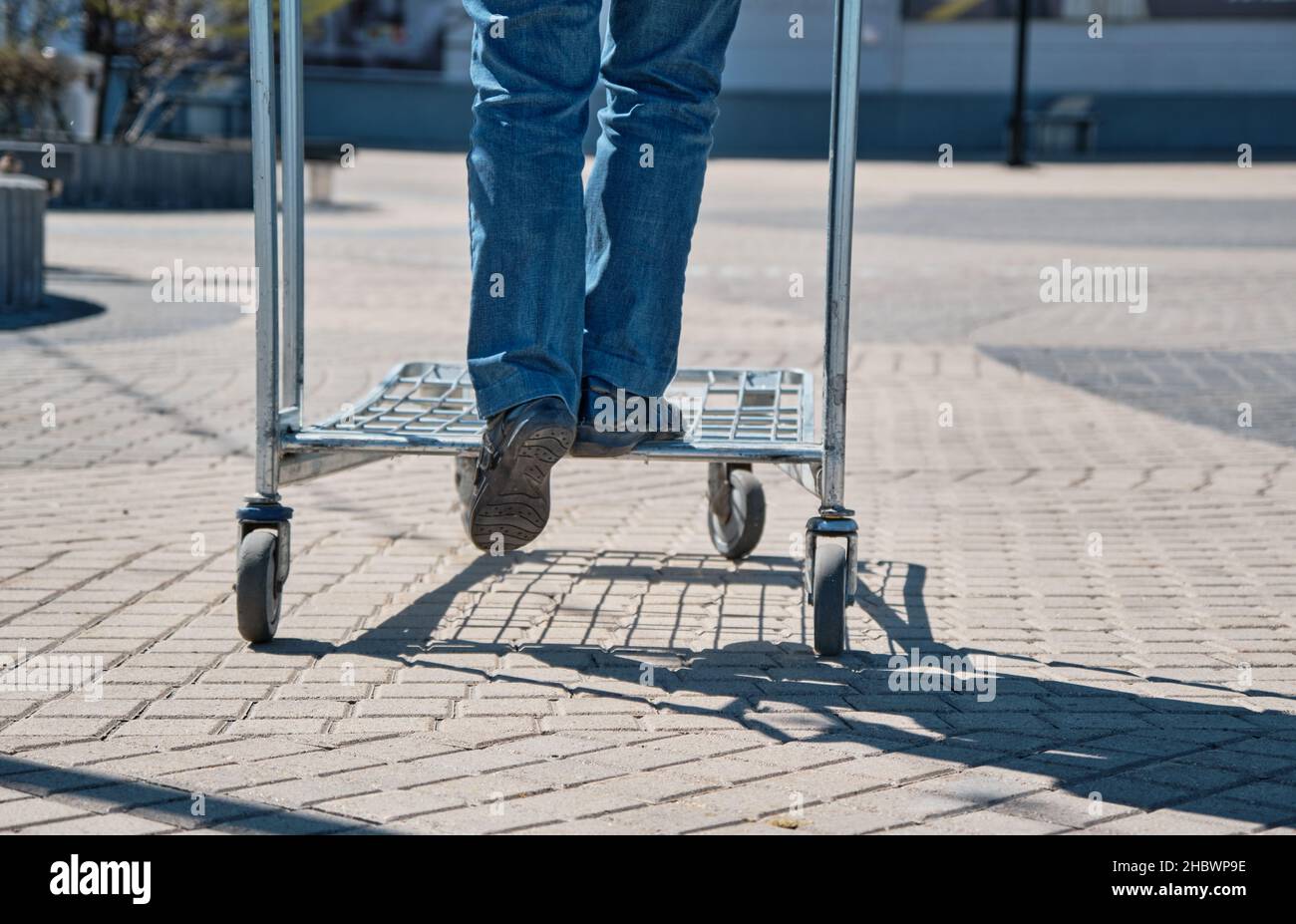 Person approaches cart for transporting things, pushes off with his ...