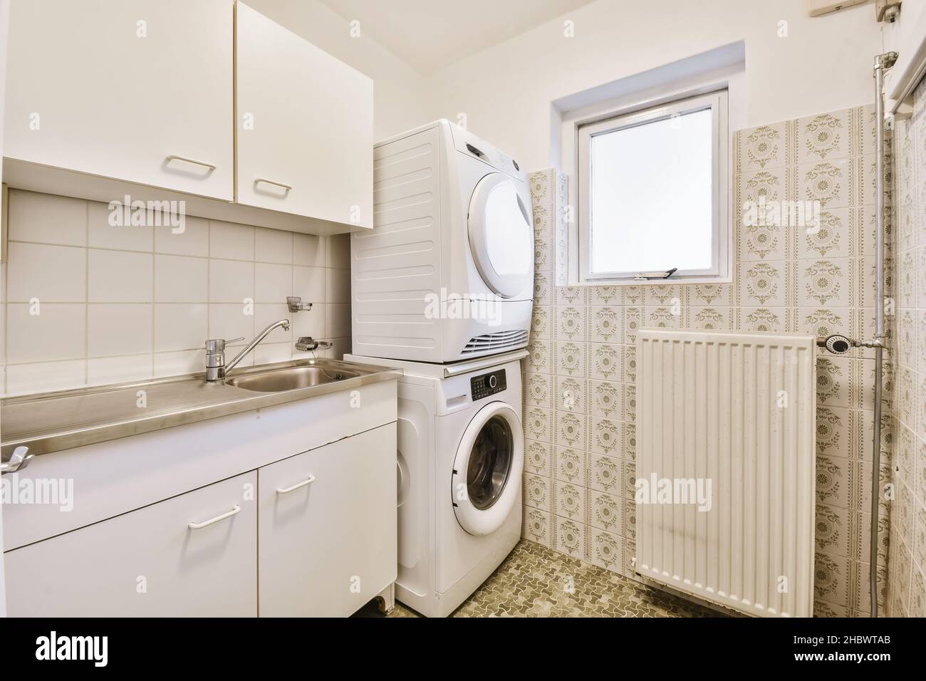 Lovely kitchen with laundry area with washing machine Stock Photo - Alamy