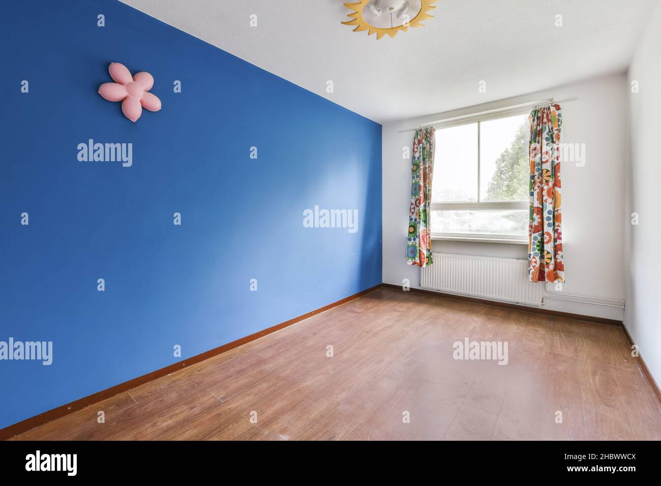 Lovely room with a window and one blue wall Stock Photo - Alamy