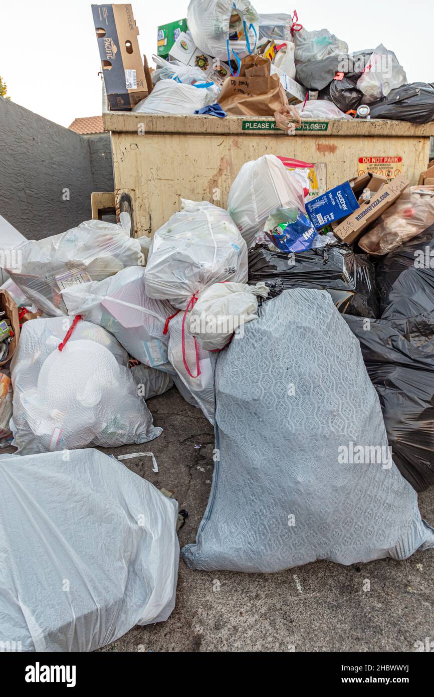 Trash overflowing from dumpster Stock Photo - Alamy