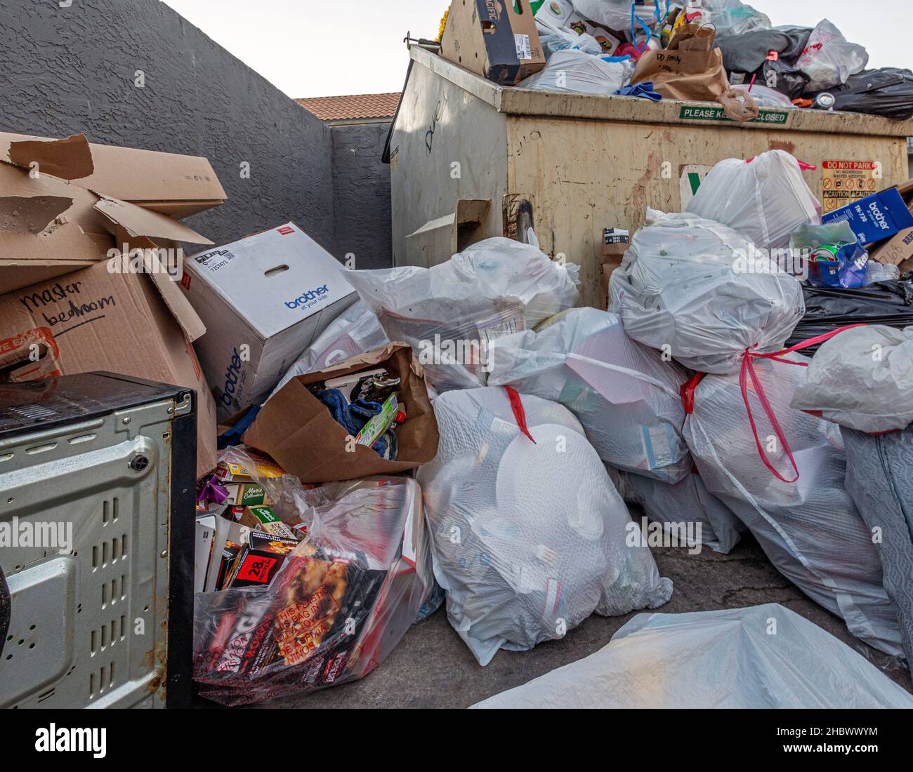 Trash overflowing from dumpster Stock Photo - Alamy