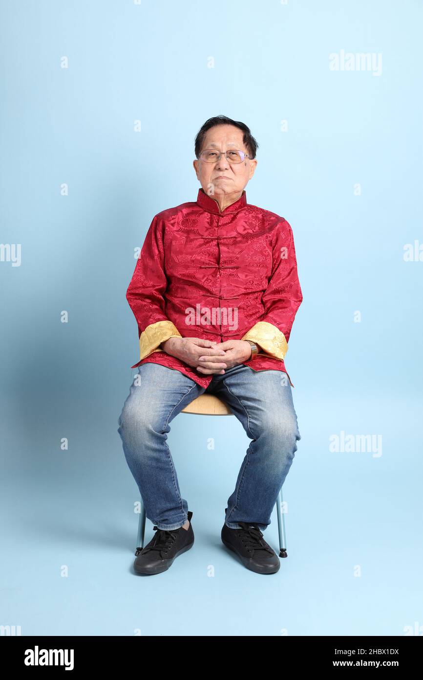 The senior Asian man wearing traditional Chinese shirt sitting on the ...