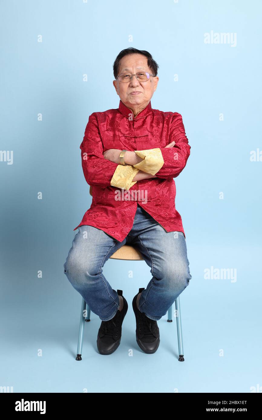 The senior Asian man wearing traditional Chinese shirt sitting on the ...