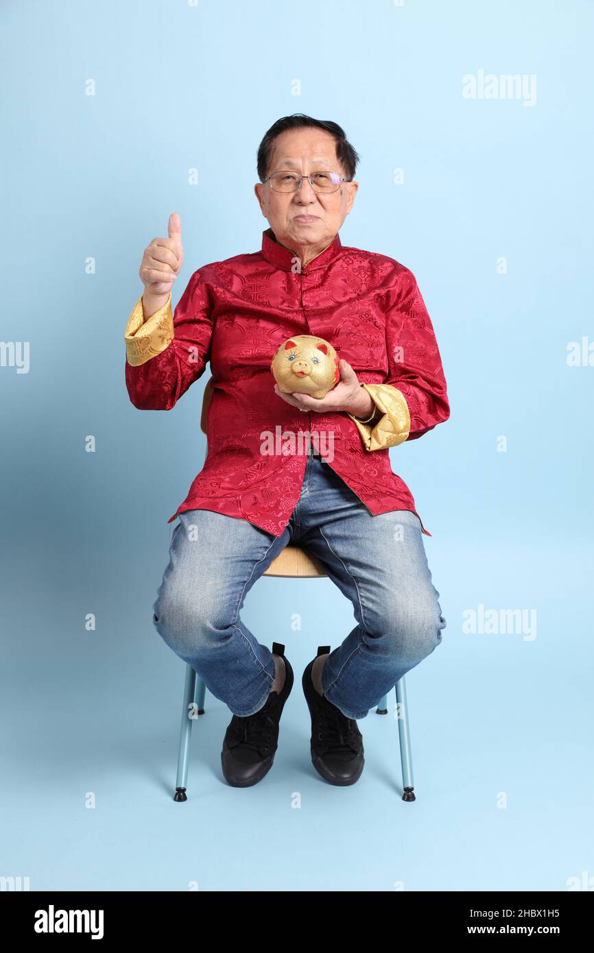 The senior Asian man wearing traditional Chinese shirt sitting on the ...