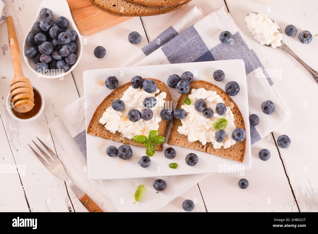 Rye bread with cottage cheese, blueberries and honey Stock Photo - Alamy