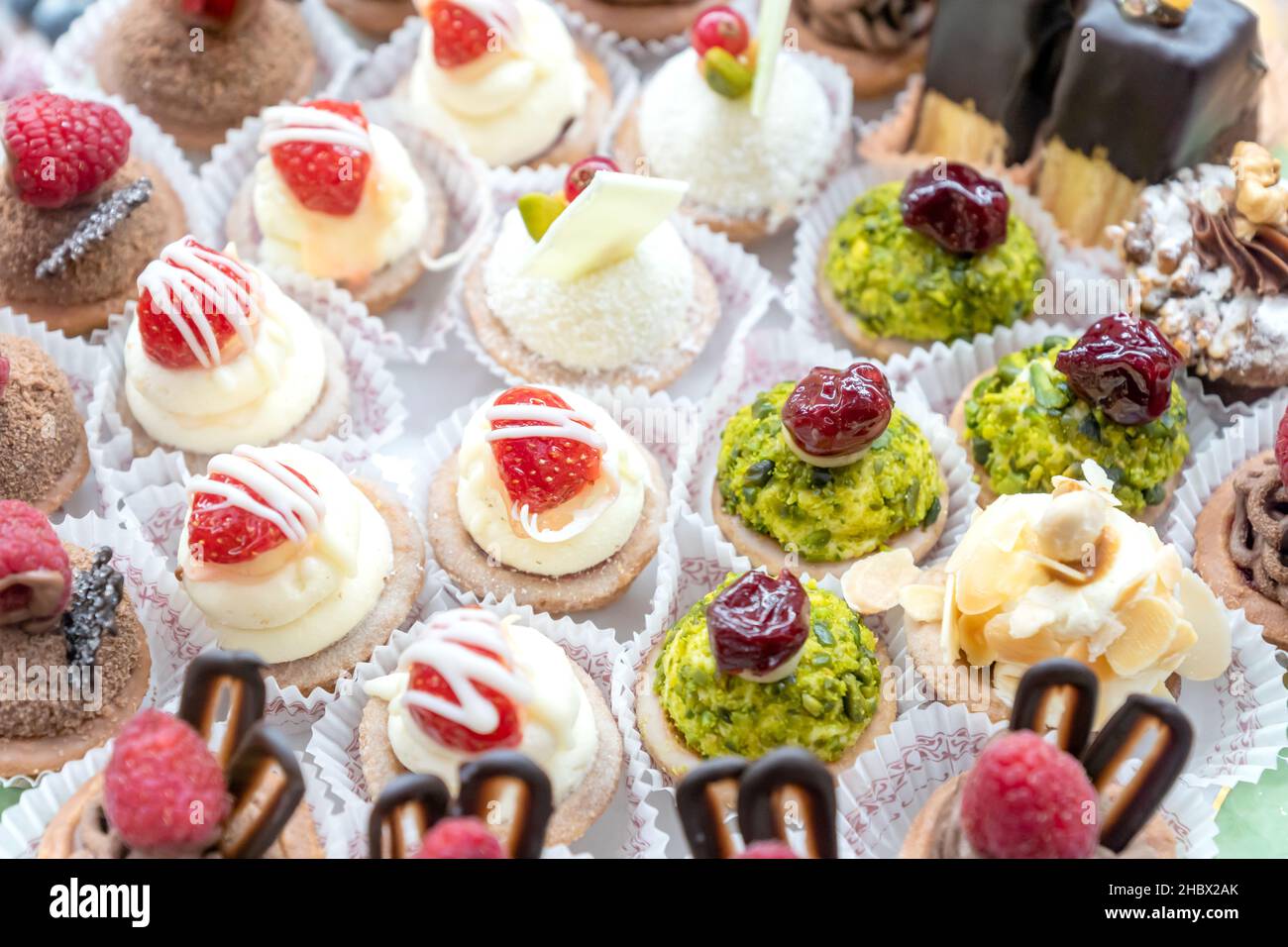 Pastry shop display window with variety of mini desserts and cakes ...