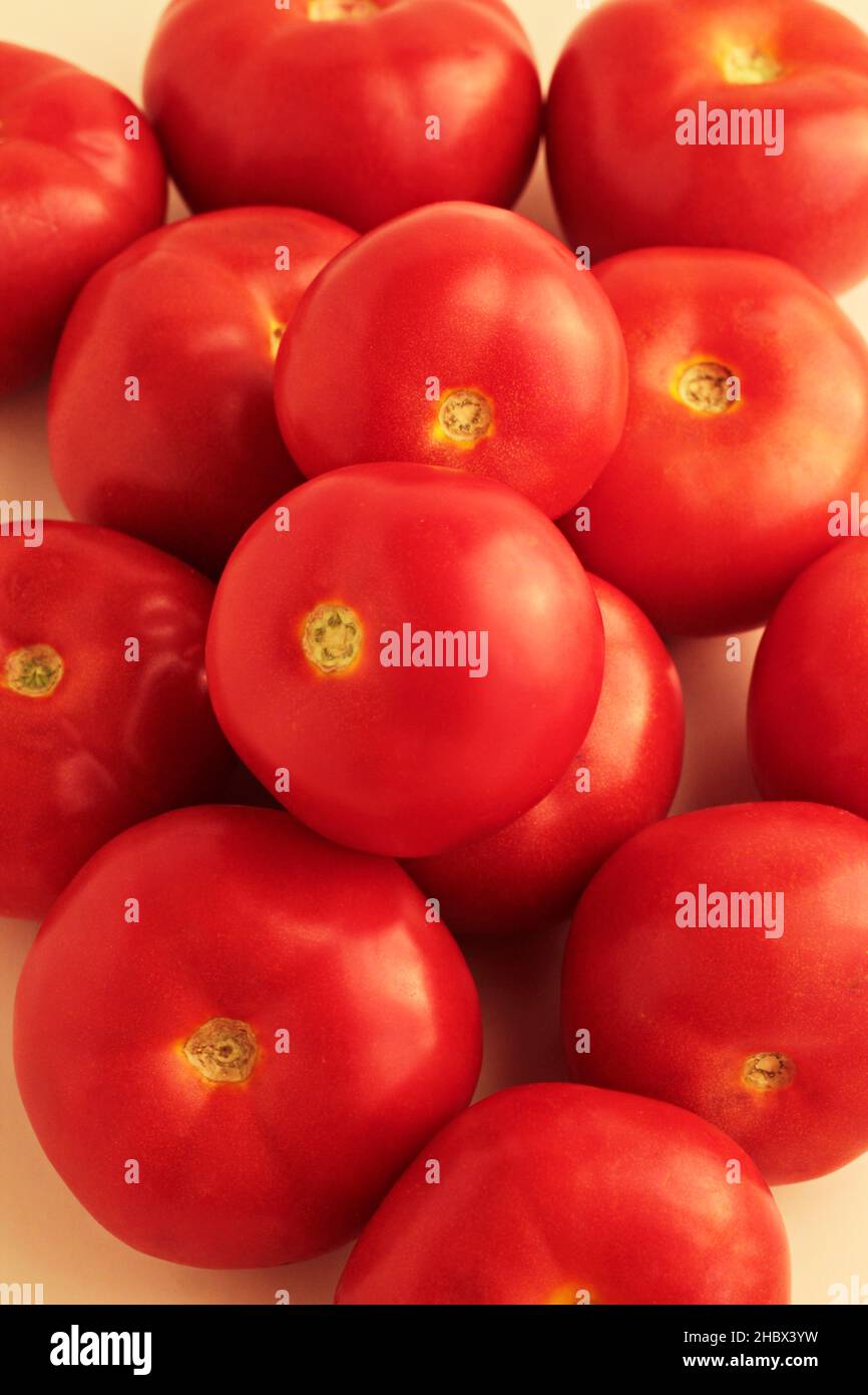 Natural,fresh field tomatoes heap on the white surface.Vertical image ...