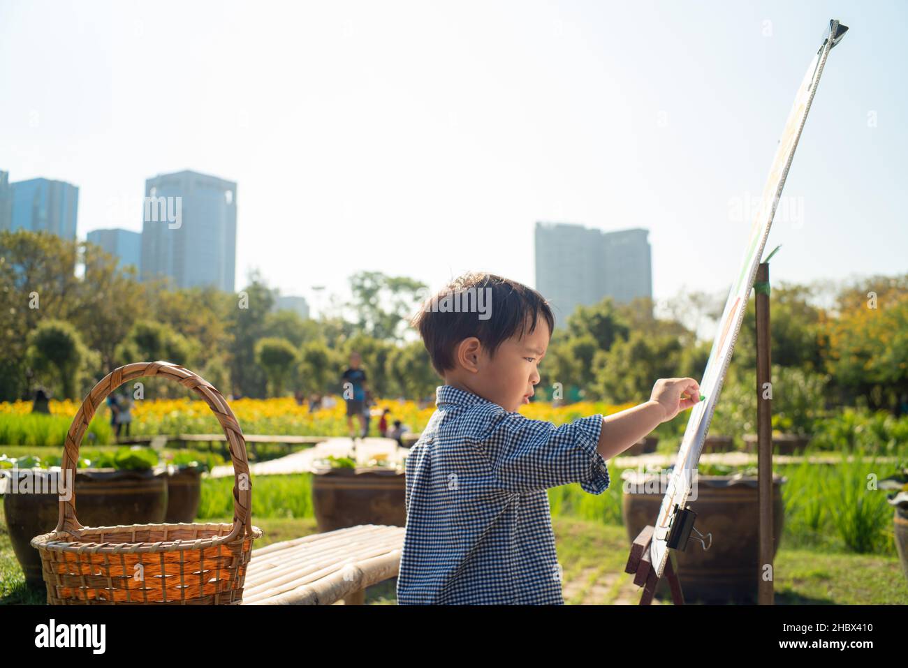 Asian kid boy drawing paint on paper in flower outdoor park Stock Photo ...