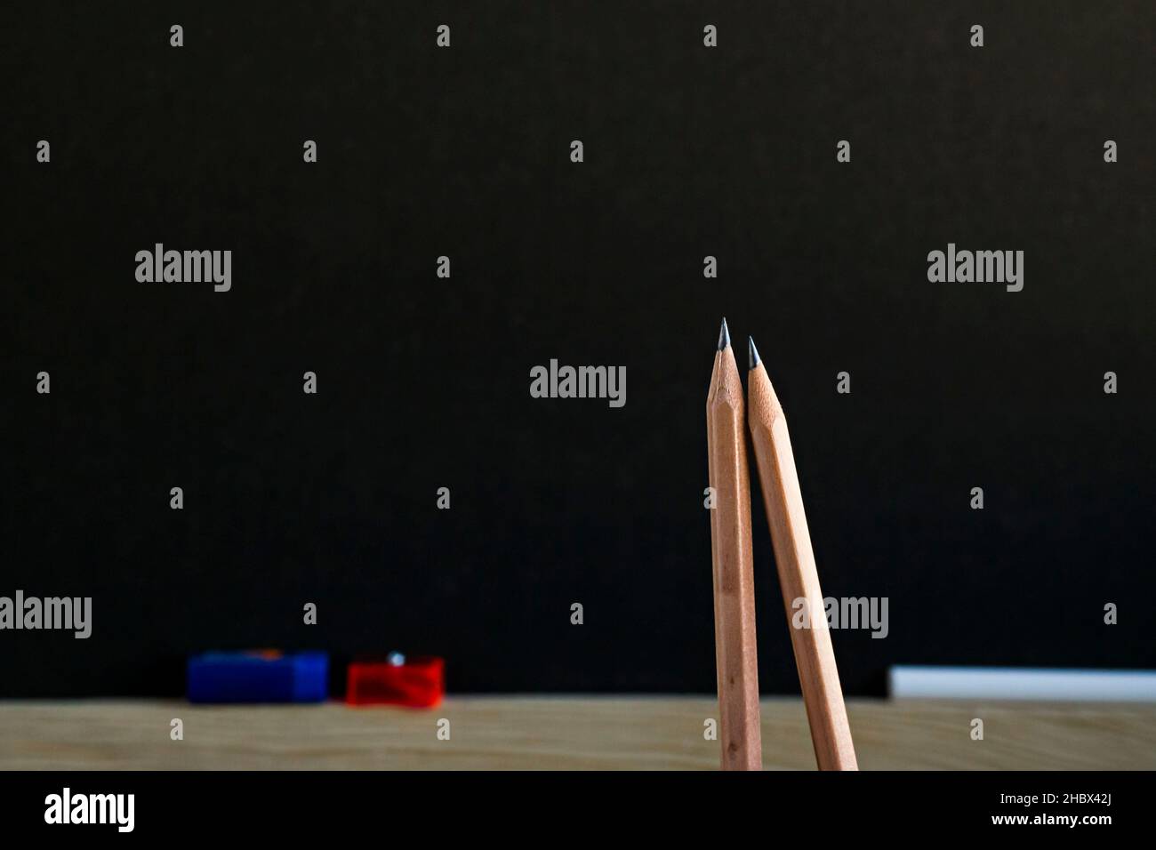 Natural wood pencils leaning againist each other in front of blurred ...