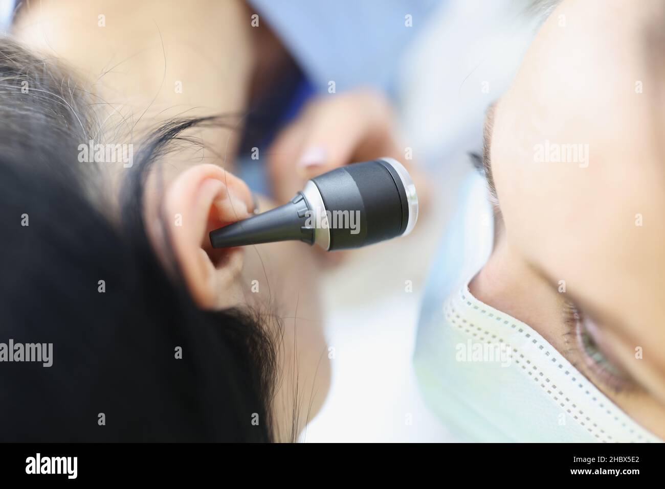 Doctor check patient on medical examination with special ear equipment ...