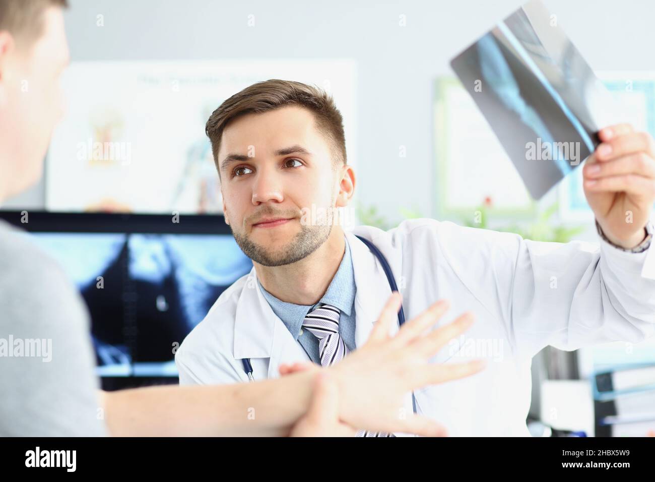 Smiling doctor talking with patient about good x ray results Stock ...