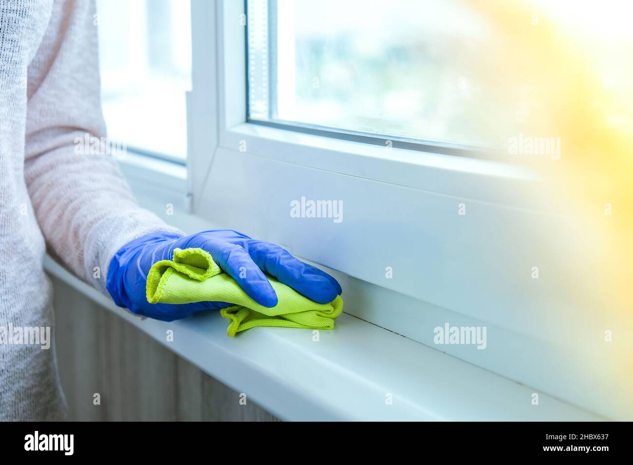 Cleaning the windowsill wiping dust by blue microfiber cloth for ...