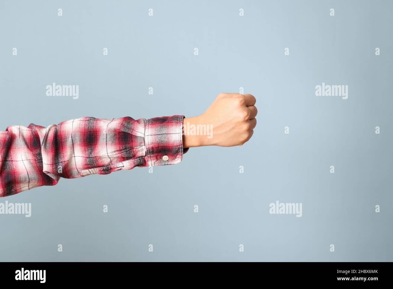 The Asian man hand with plaid shirt showing on the blue background ...
