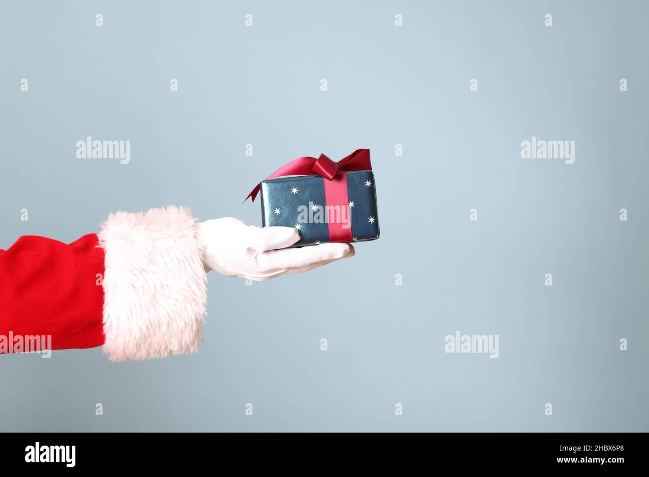 The Santa Claus hand showing on the blue background Stock Photo - Alamy