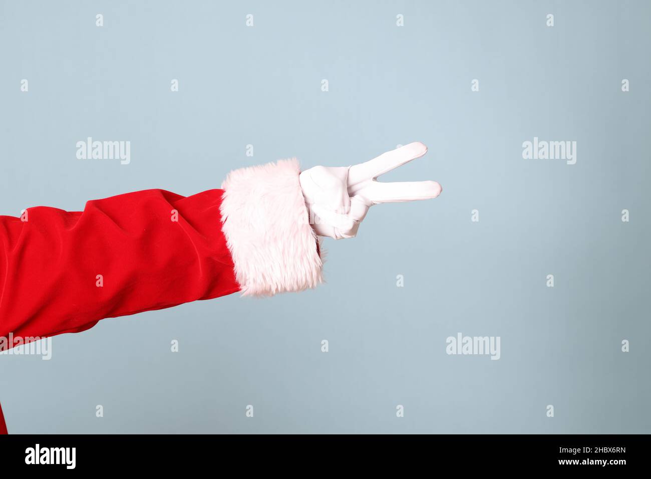 The Santa Claus hand showing on the blue background Stock Photo - Alamy