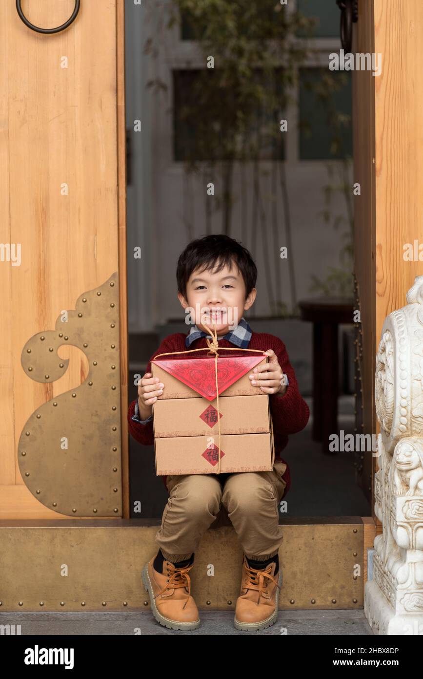 Little boy holding gift boxes Stock Photo - Alamy