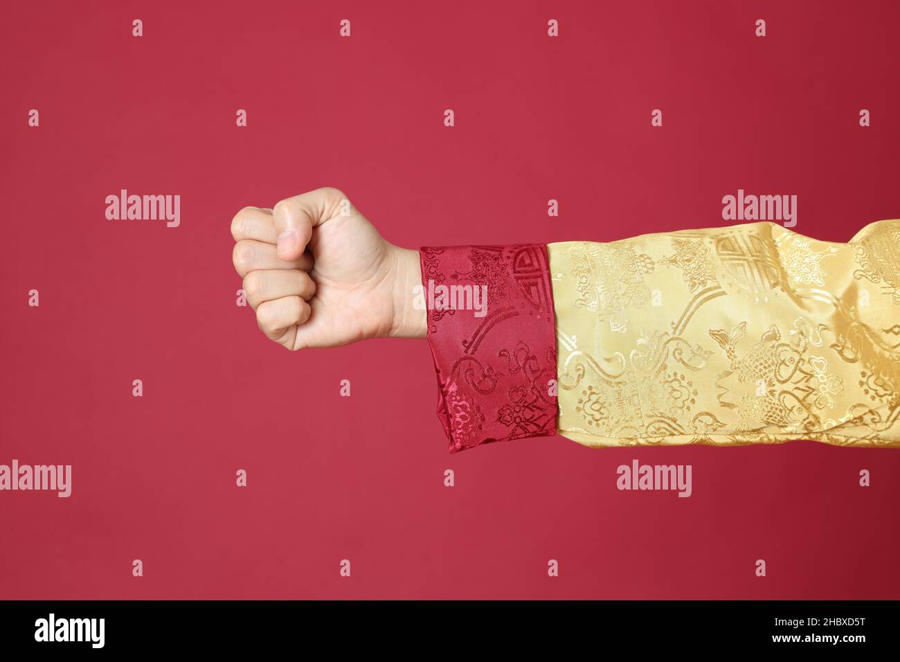 The Chinese man hand with tradion dressed on the red background Stock ...
